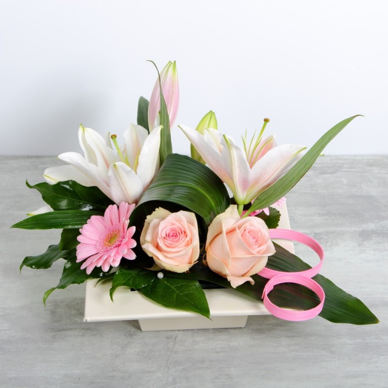 Composition de lys, roses et travail de feuillage dans une base zinc